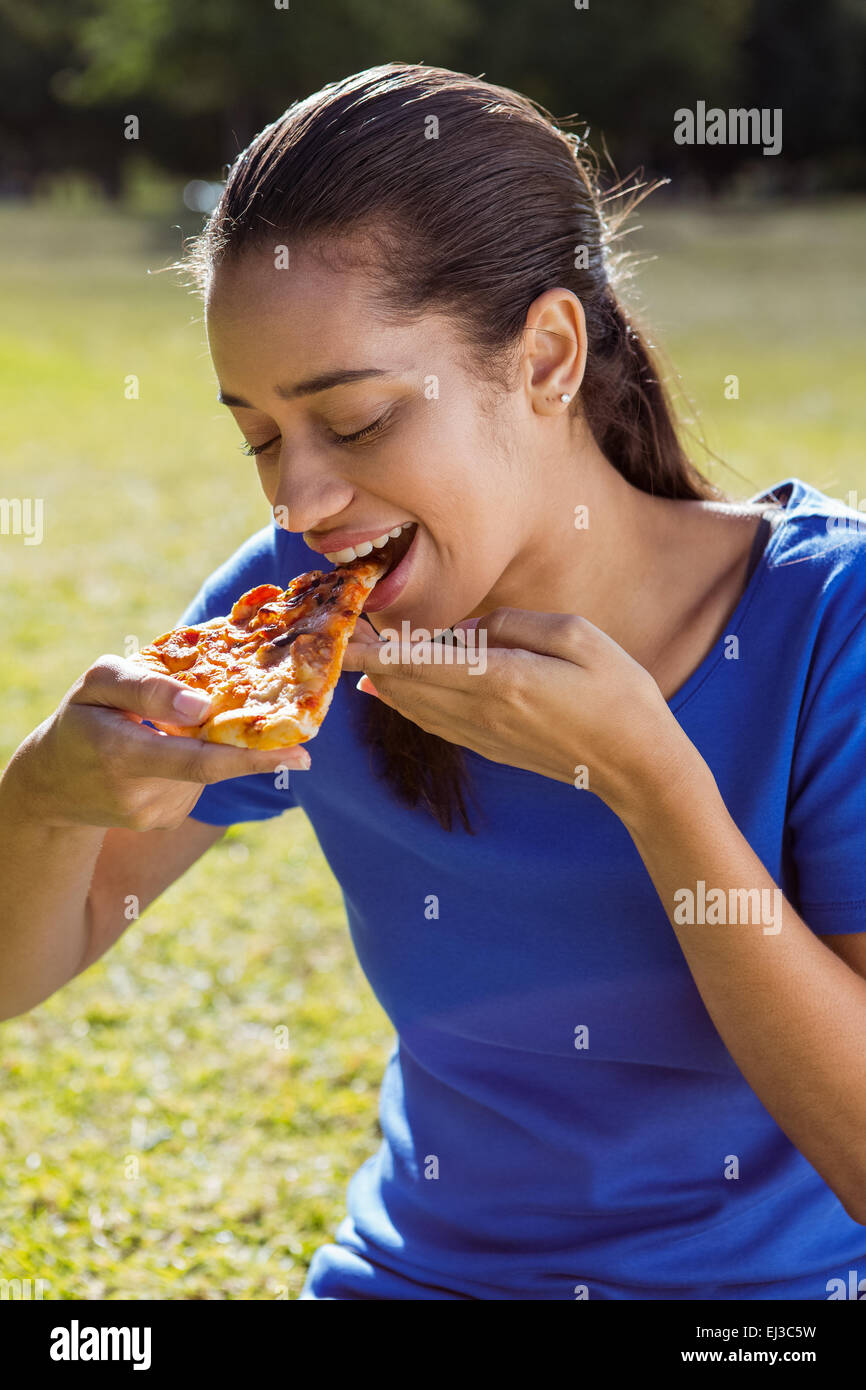 Pretty woman eating pizza in the park Stock Photo - Alamy