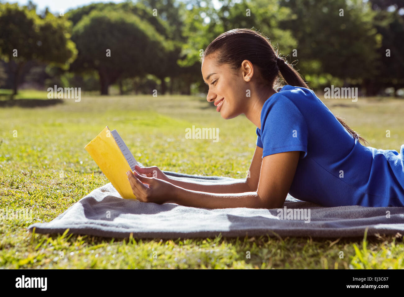 Pretty woman reading in the park Stock Photo - Alamy