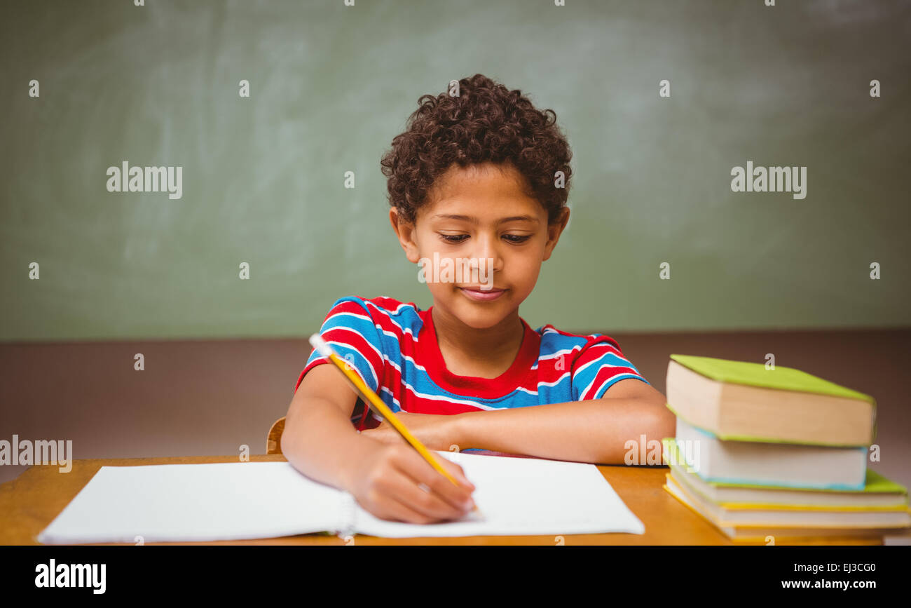 Little boy writing book in classroom Stock Photo - Alamy