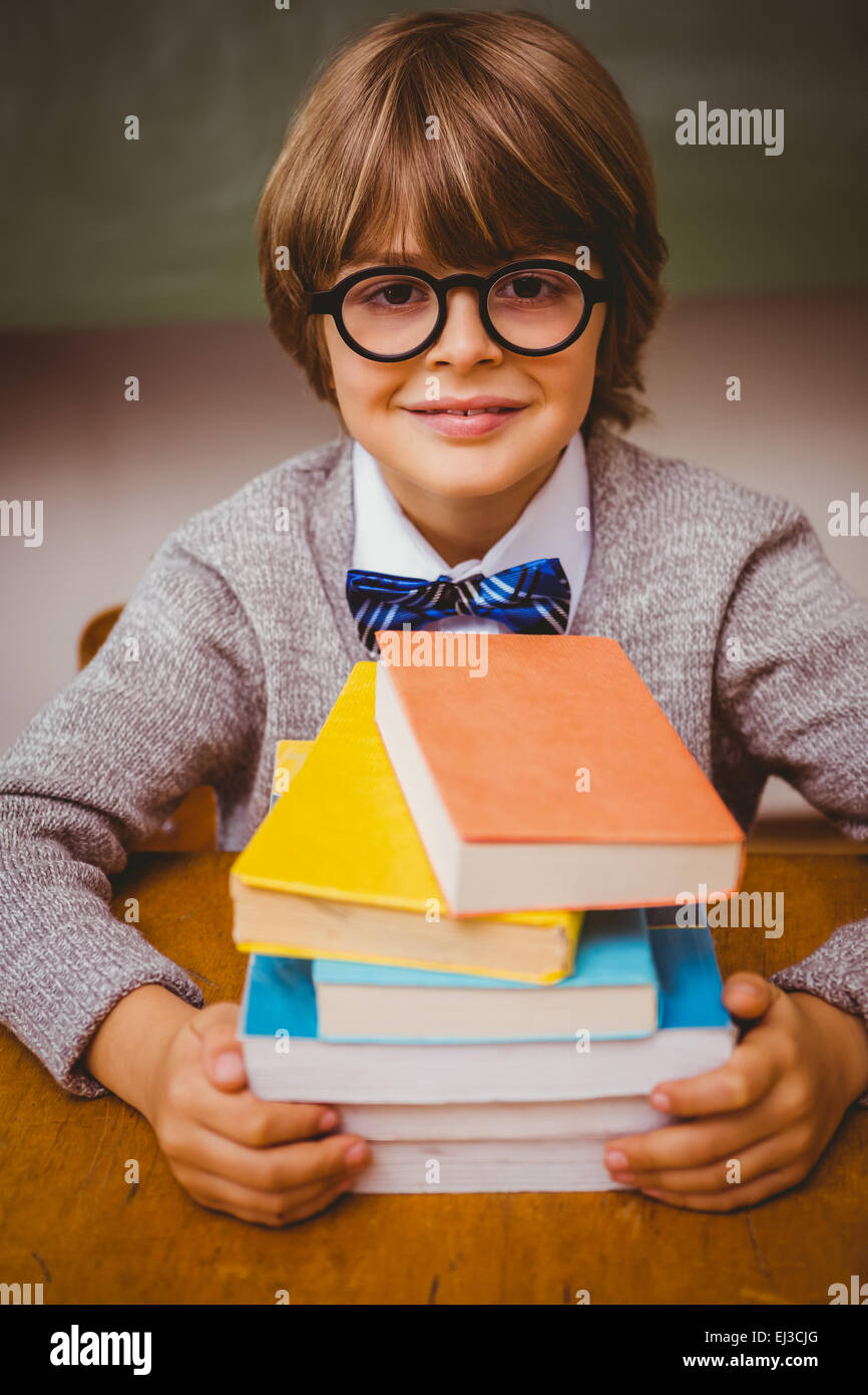 Boy with stack of books in classroom Stock Photo - Alamy