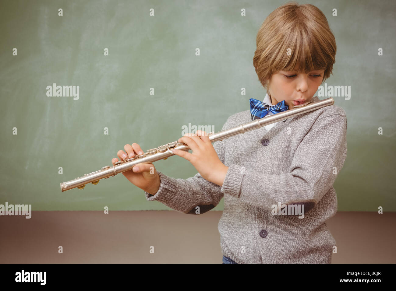 Little boy playing flute in classroom Stock Photo - Alamy