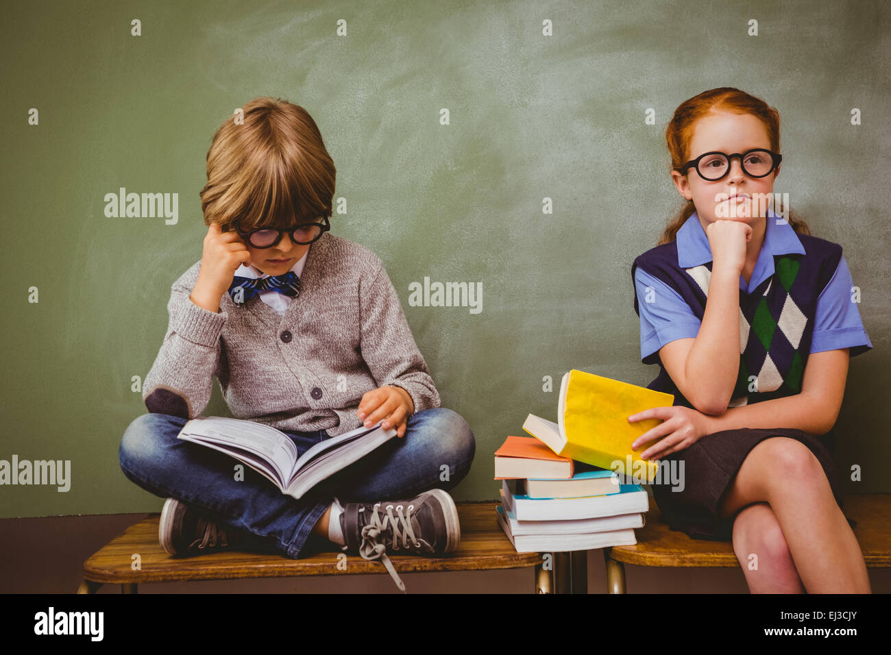 Kids with stack of books in classroom Stock Photo - Alamy