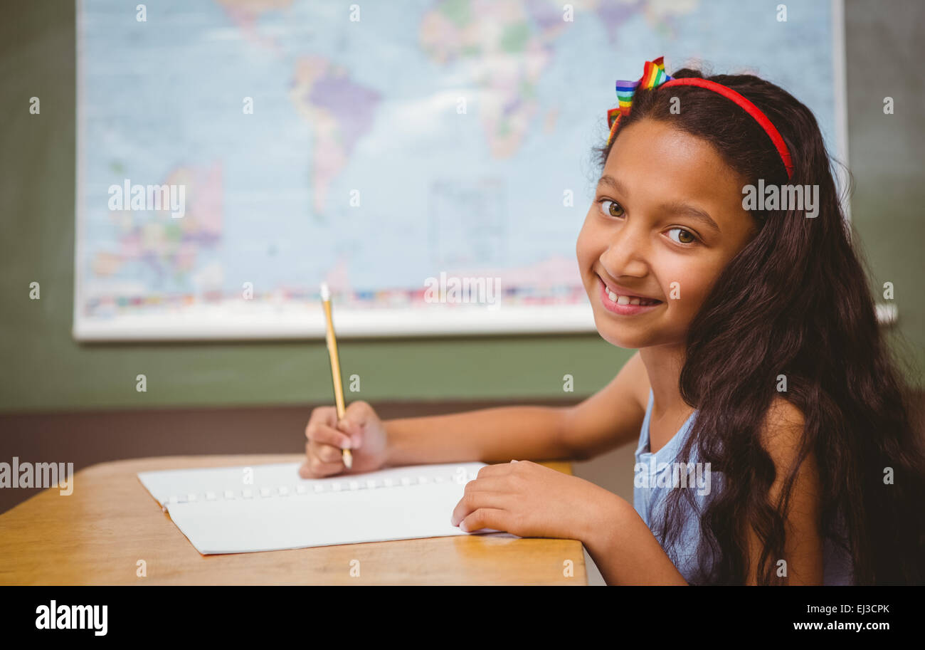 Cute little girl writing book in classroom Stock Photo - Alamy