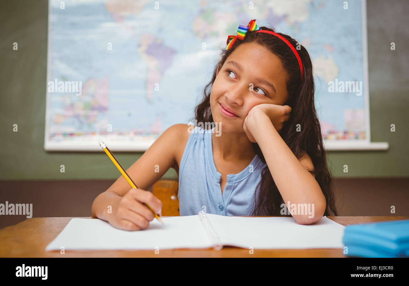 Girl writing book in classroom Stock Photo - Alamy