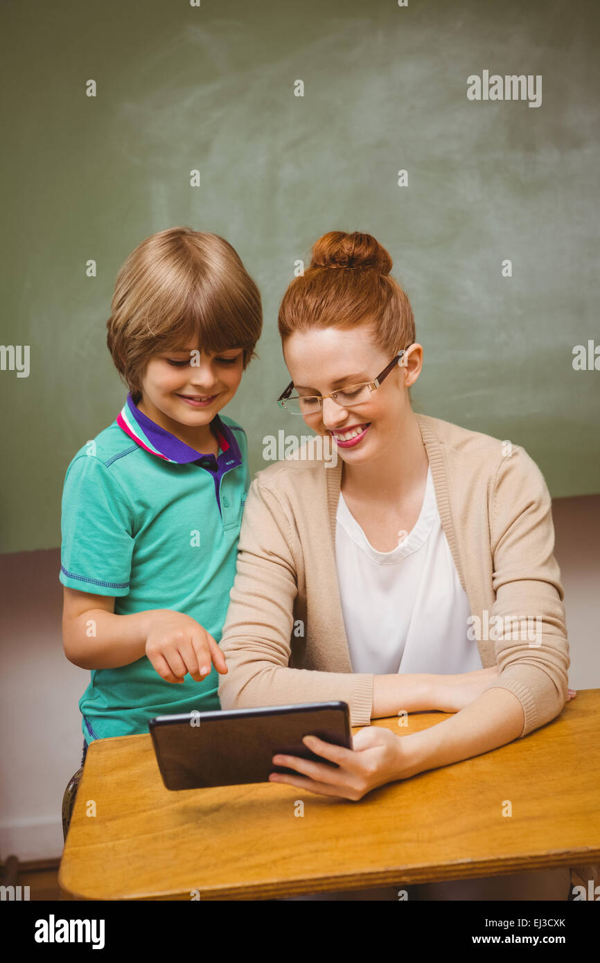 Teacher and boy using digital tablet in classroom Stock Photo - Alamy