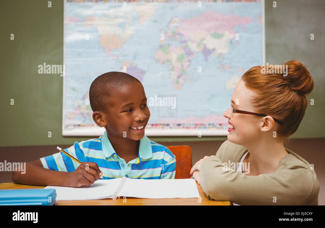 Teacher assisting little boy with homework in classroom Stock Photo - Alamy