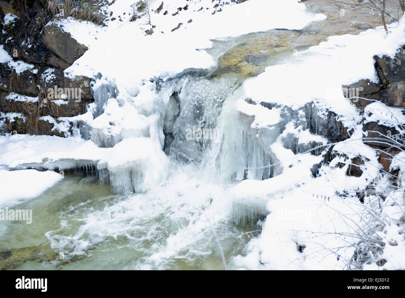 Beautiful waterfall on fast mountain river at winter Stock Photo - Alamy