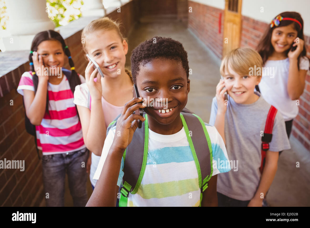 School kids using cellphones in school corridor Stock Photo - Alamy