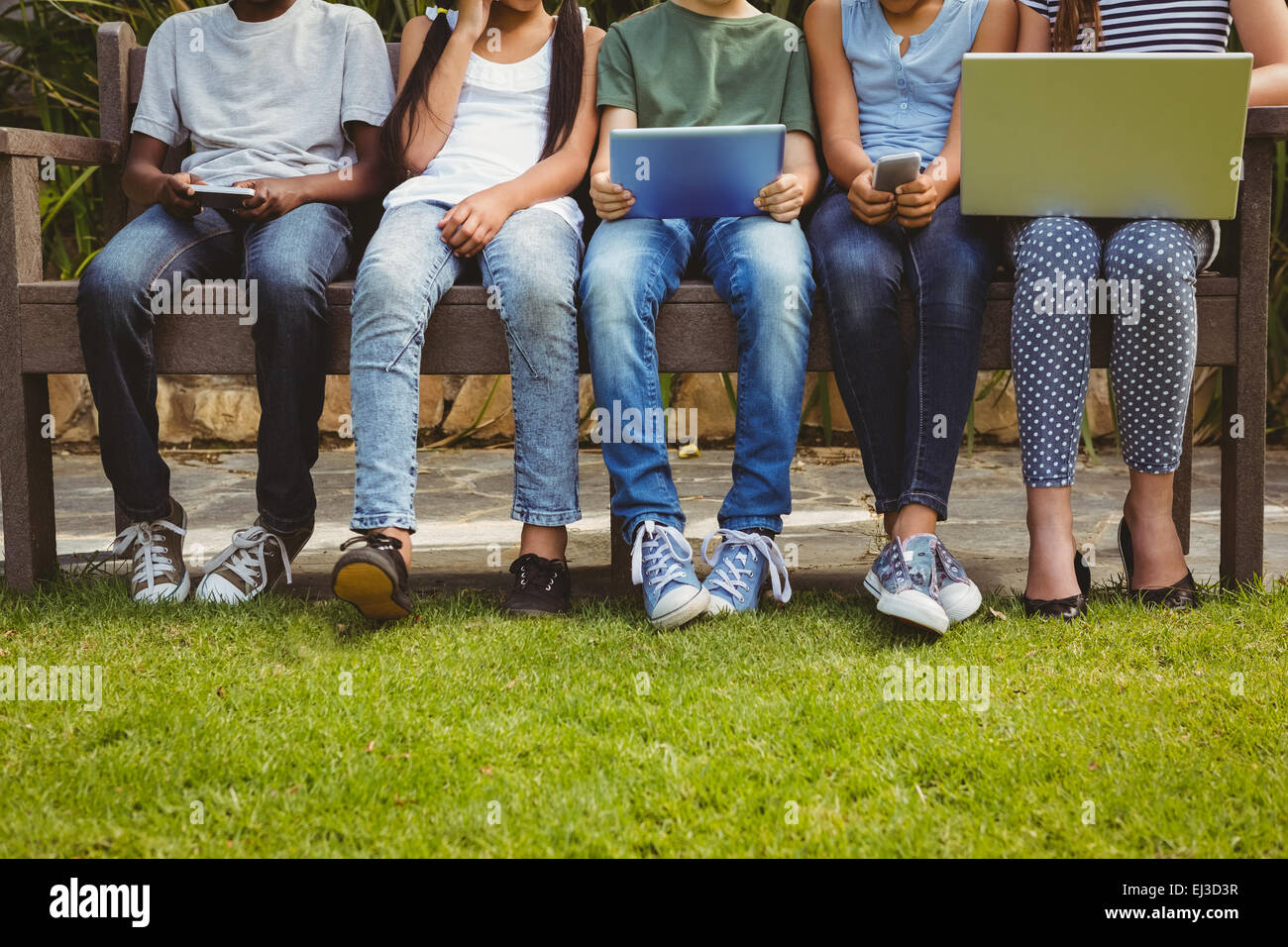 Children using technologies at park Stock Photo - Alamy