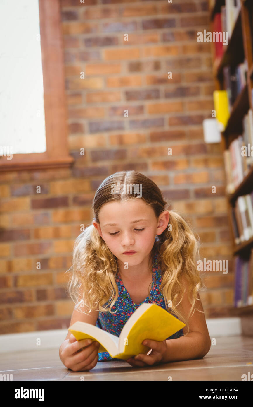 Girl reading book in library Stock Photo - Alamy