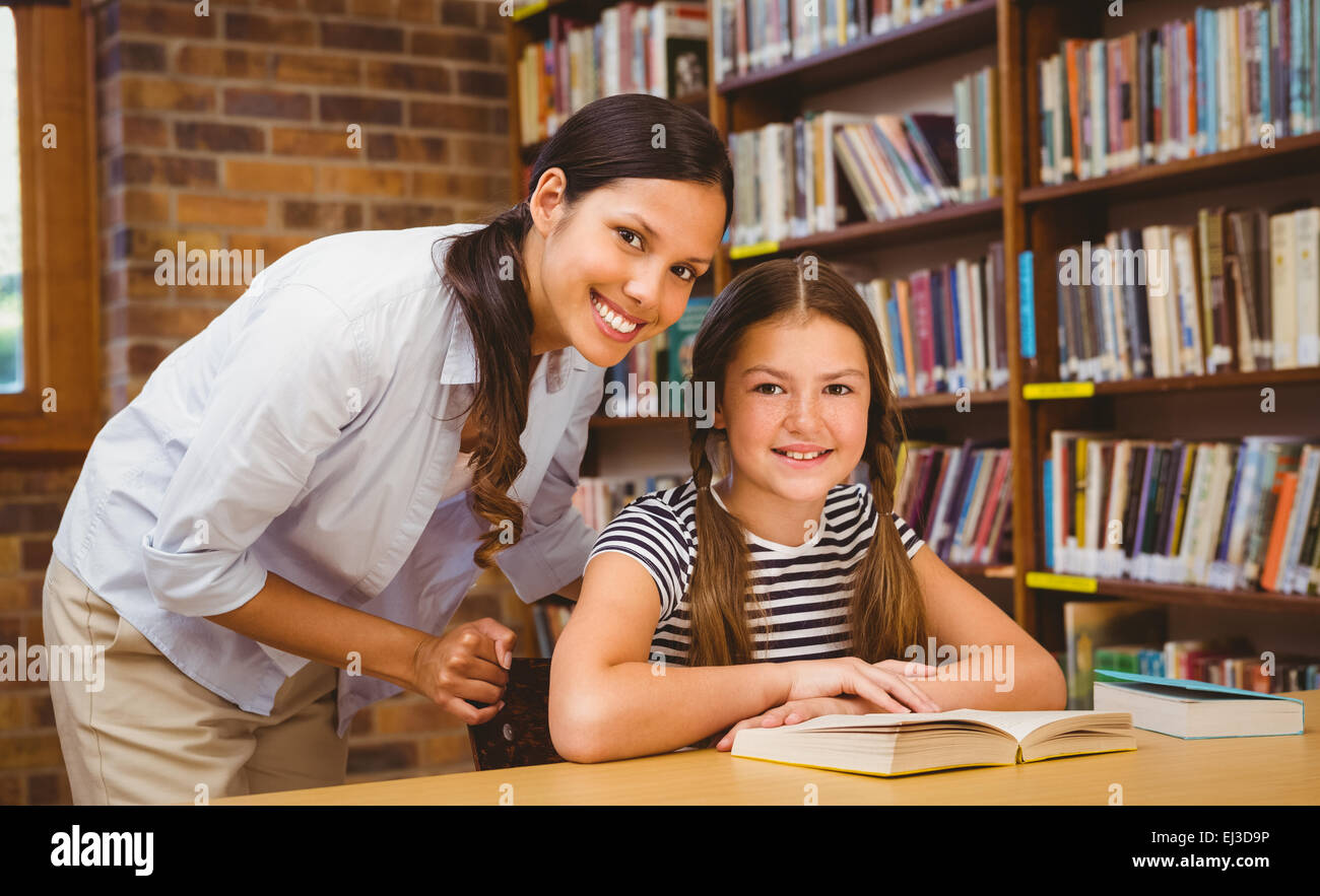 Female teacher and little girl in library Stock Photo - Alamy