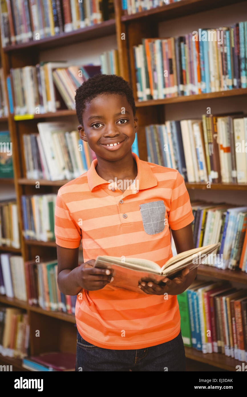 Cute boy reading book in library Stock Photo - Alamy