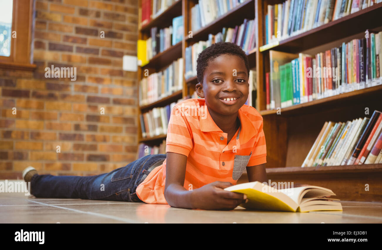 Cute boy reading book in library Stock Photo - Alamy