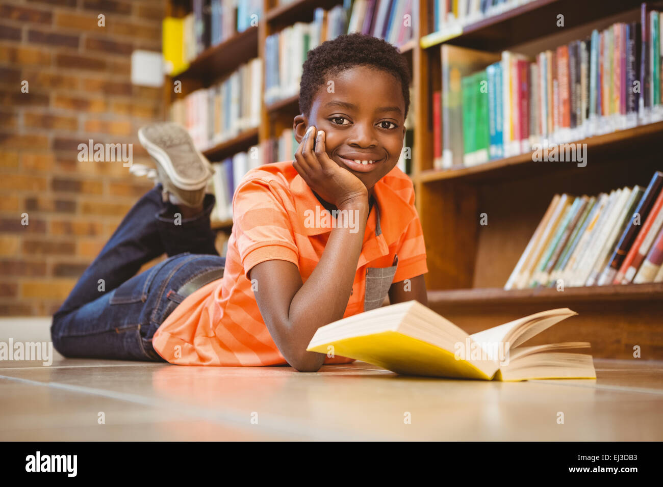 Cute boy reading book in library Stock Photo - Alamy