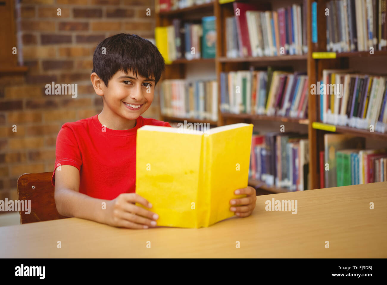 Portrait of boy reading book in library Stock Photo - Alamy
