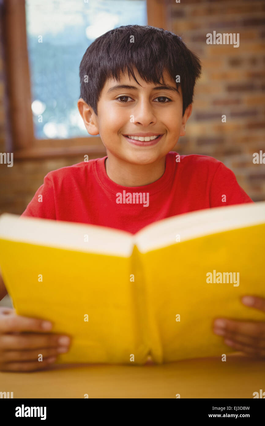 Portrait of boy reading book in library Stock Photo - Alamy
