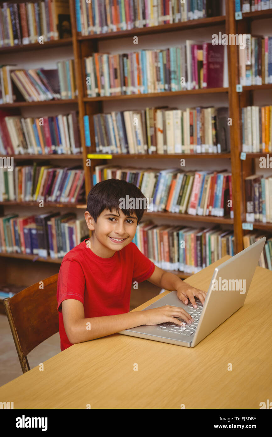 Portrait of boy using laptop in library Stock Photo - Alamy