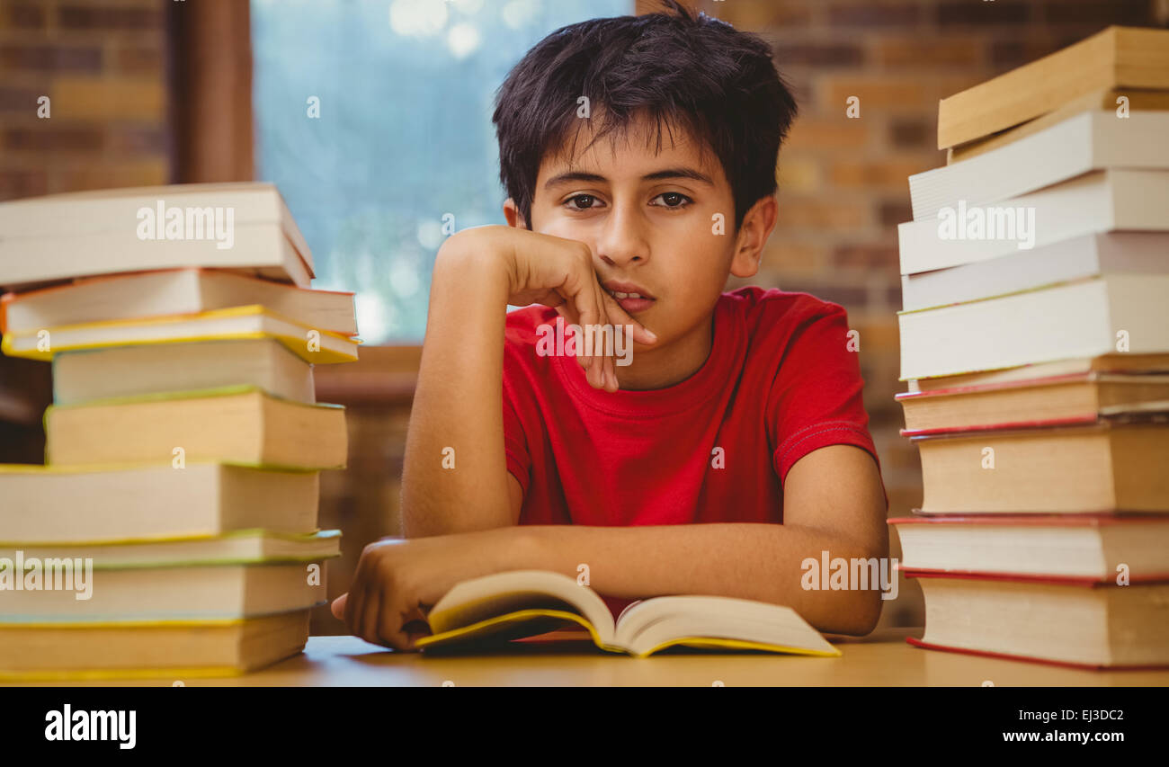 Tensed boy sitting with stack of books Stock Photo - Alamy