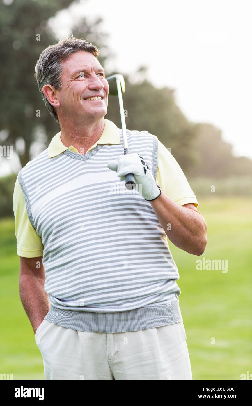 Golfer standing and swinging his club smiling at camera Stock Photo - Alamy