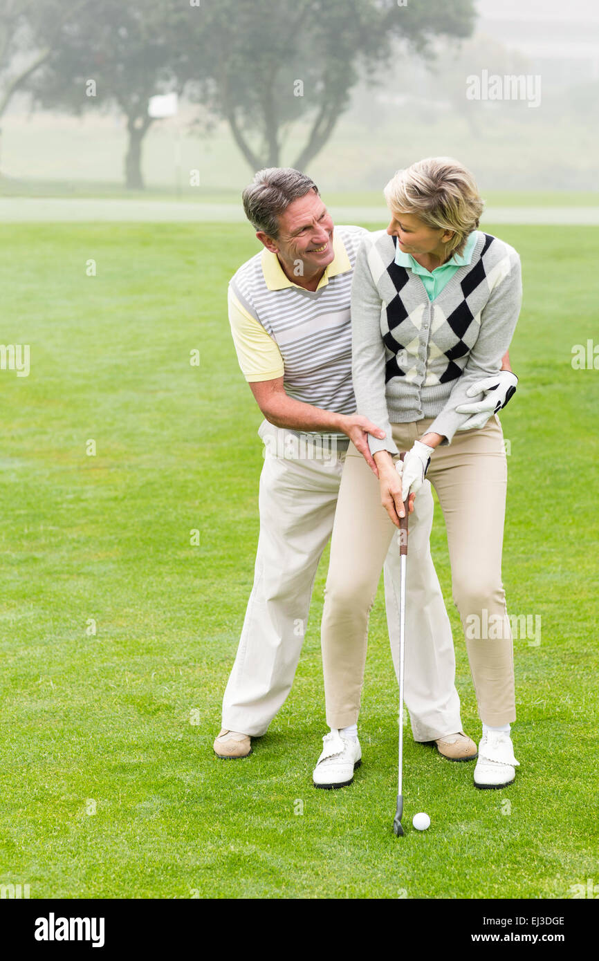Golfing couple putting ball together Stock Photo - Alamy