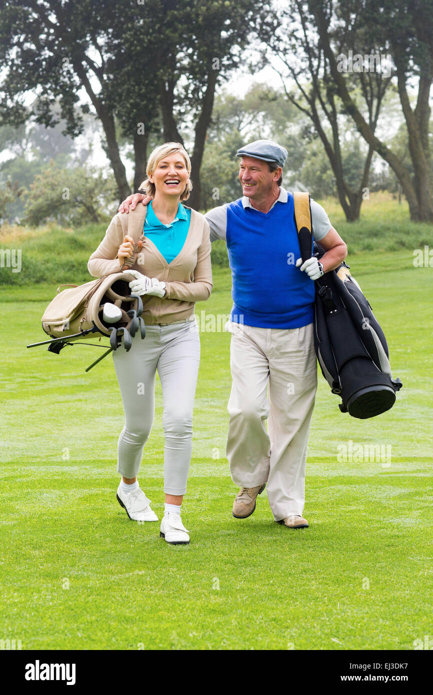 Golfing couple smiling at each other on the putting green Stock Photo ...