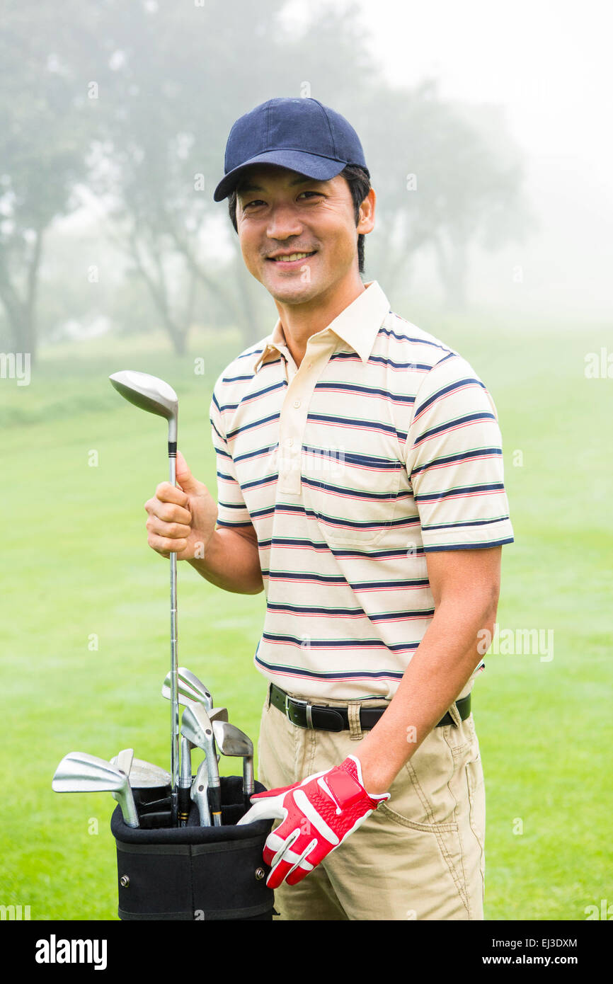 Happy golfer taking club from golf bag Stock Photo - Alamy