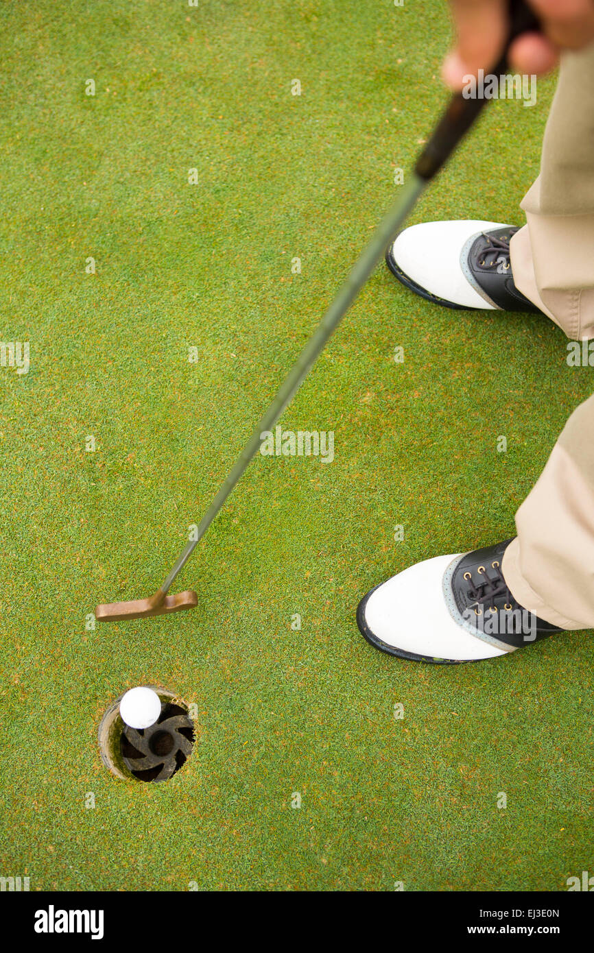 Golfer putting golf ball in the hole Stock Photo - Alamy
