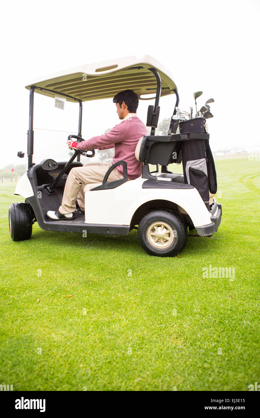 Golfer driving in his golf buggy Stock Photo - Alamy