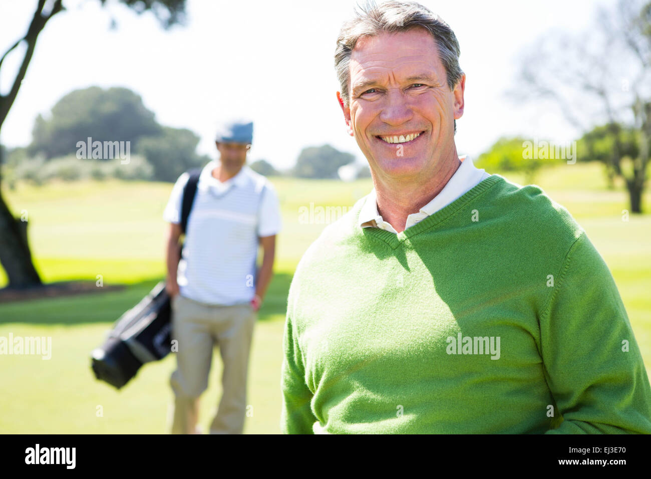 Golfing friends smiling at camera Stock Photo - Alamy