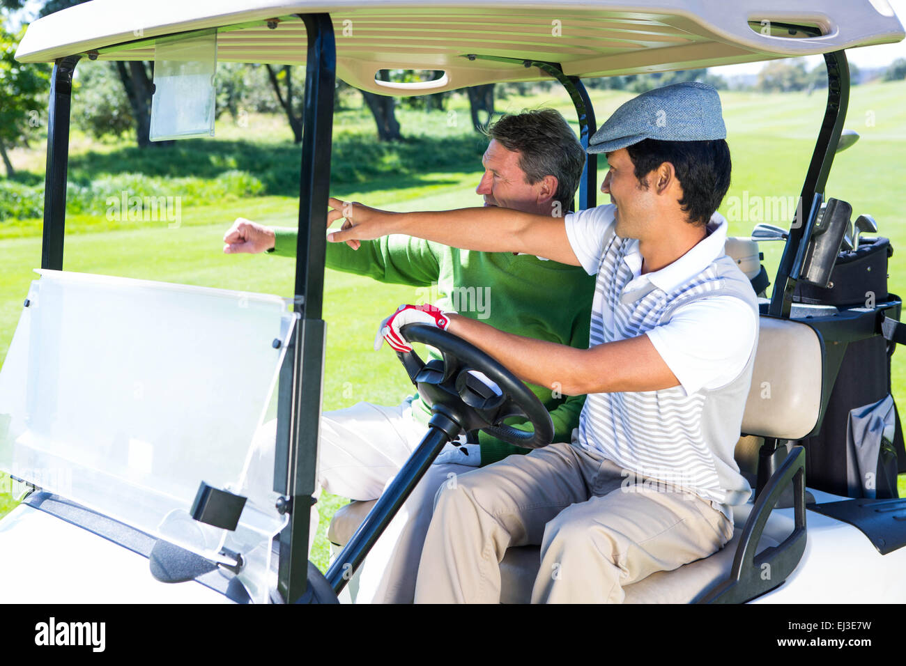 Golfing friends driving in their golf buggy Stock Photo - Alamy