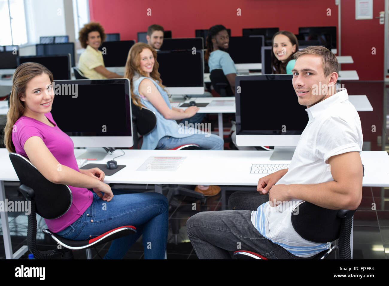 Smiling students in computer class Stock Photo - Alamy
