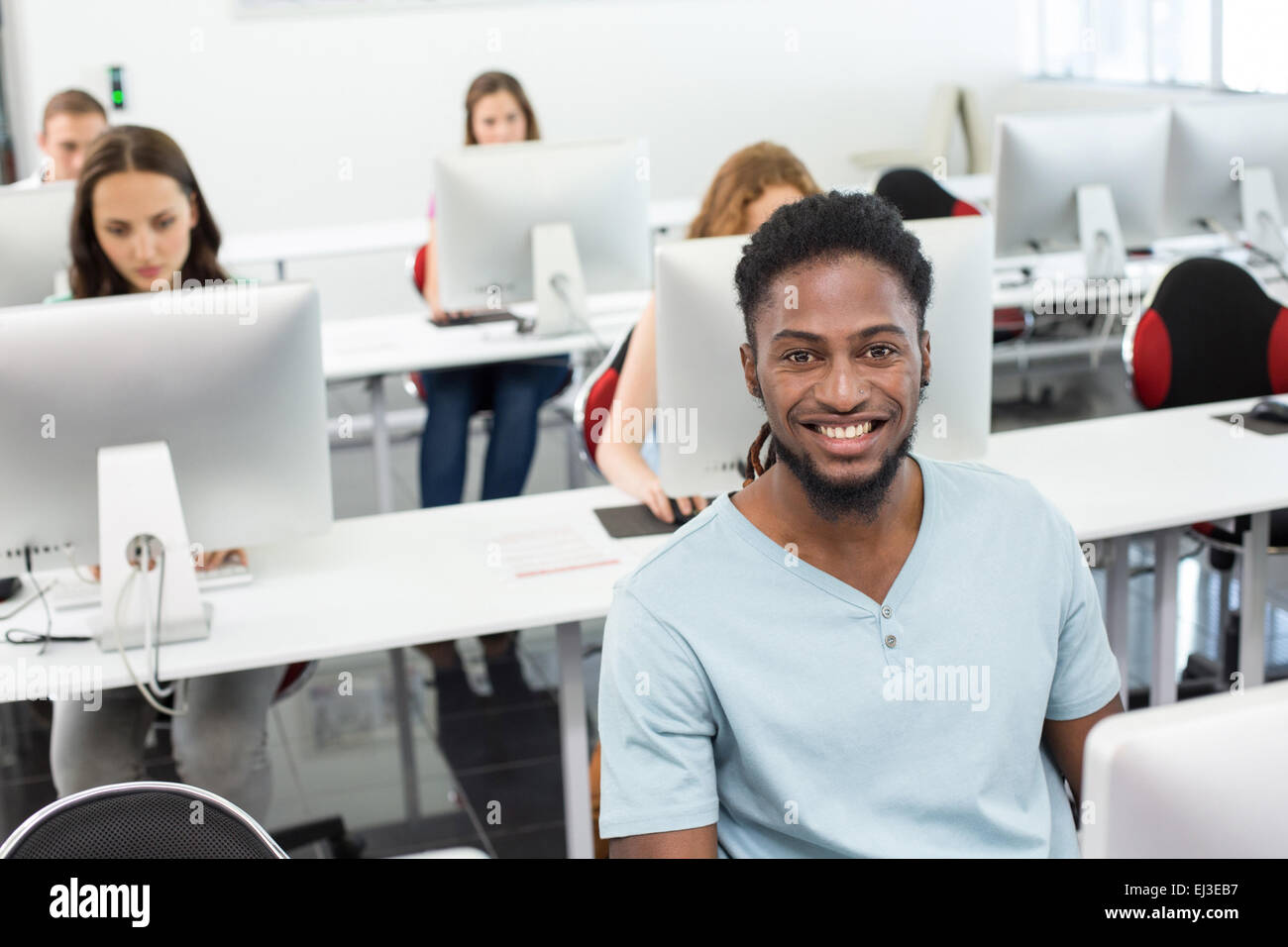 Smiling students in computer class Stock Photo - Alamy