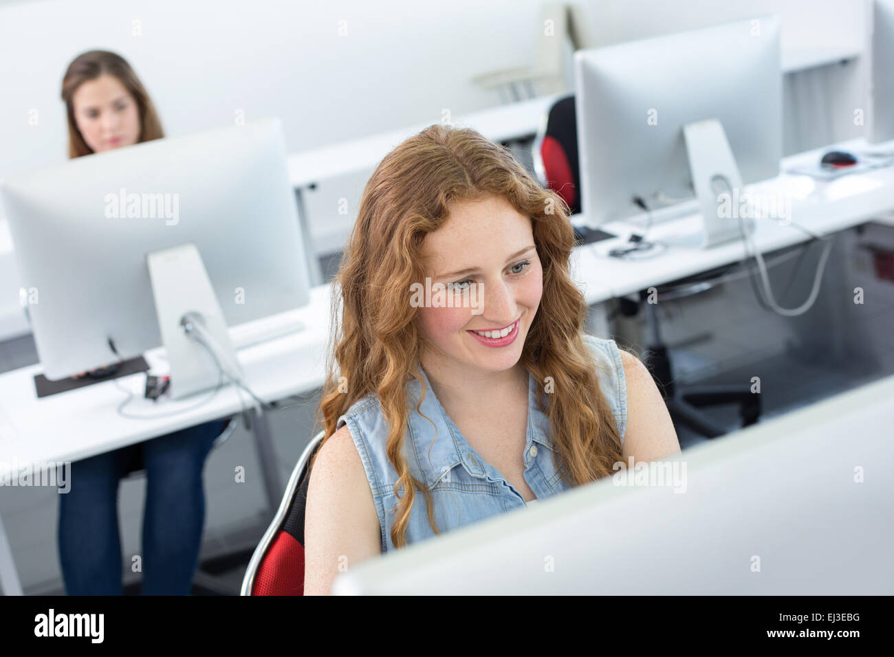 Smiling female student in computer class Stock Photo - Alamy
