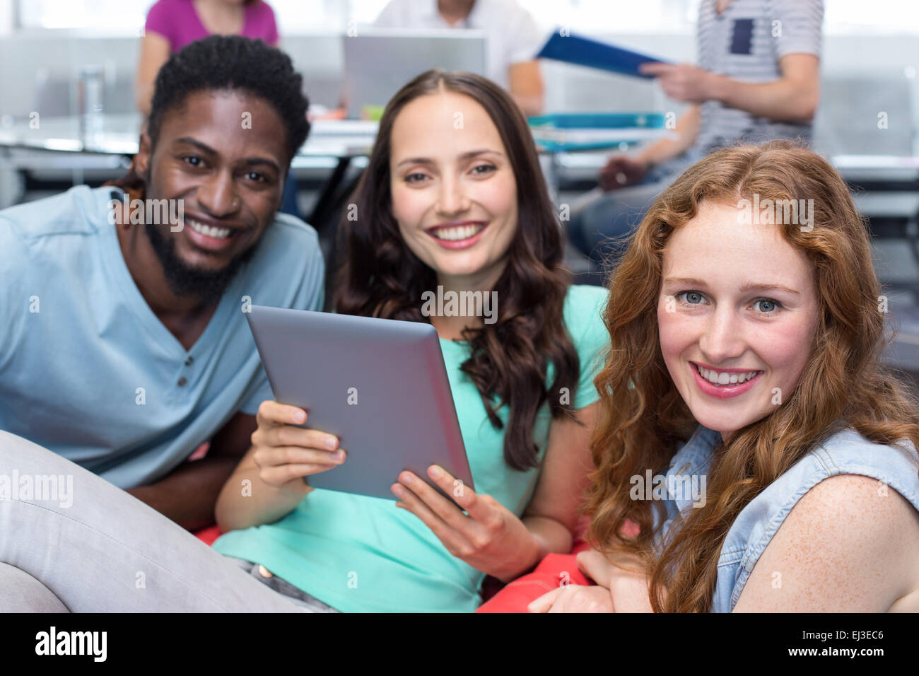 Happy students looking tablet together hi-res stock photography and ...