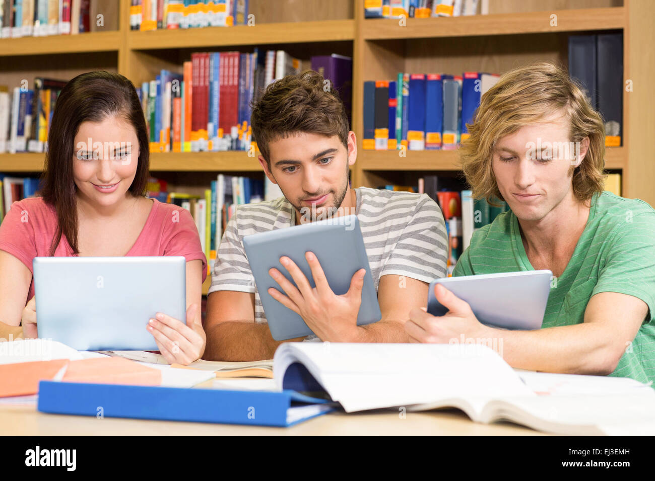 College students using digital tablets in library Stock Photo - Alamy