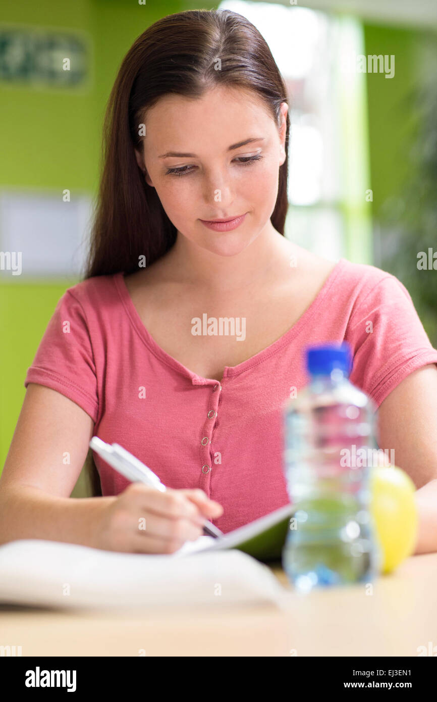 Female student doing homework in library Stock Photo - Alamy