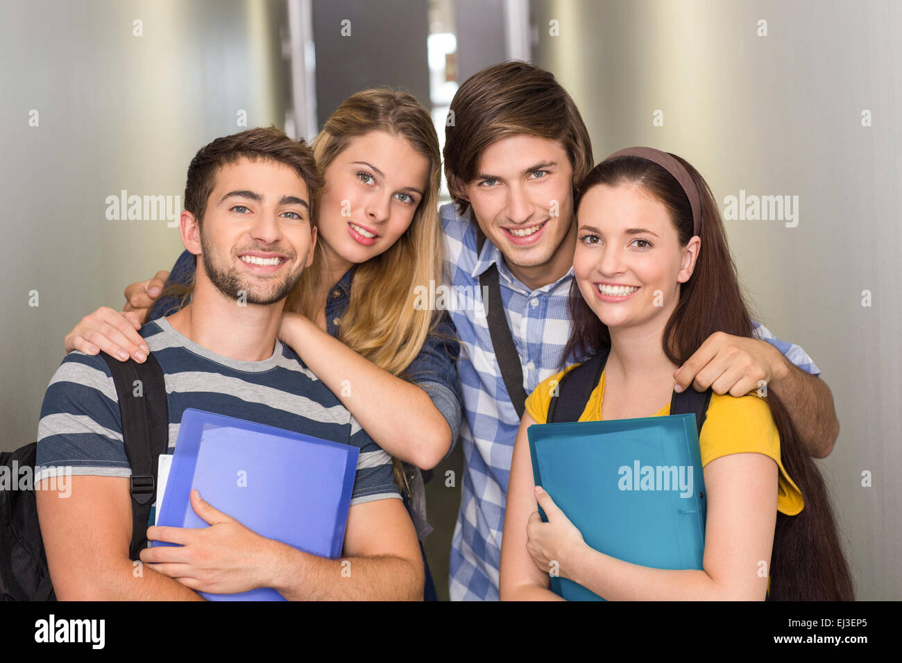 Students holding folders at college corridor Stock Photo - Alamy