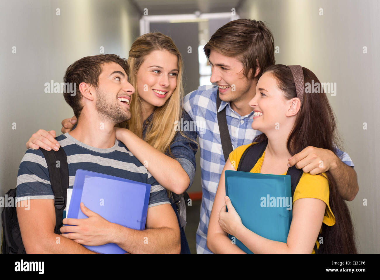 Students holding folders at college corridor Stock Photo - Alamy