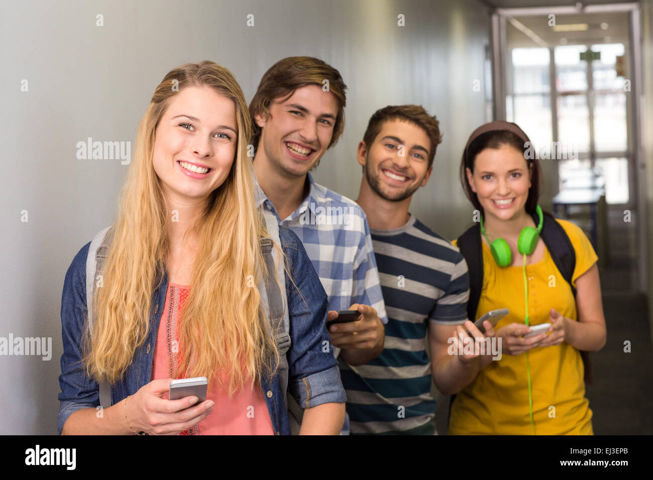 Students with cellphones at college corridor Stock Photo - Alamy