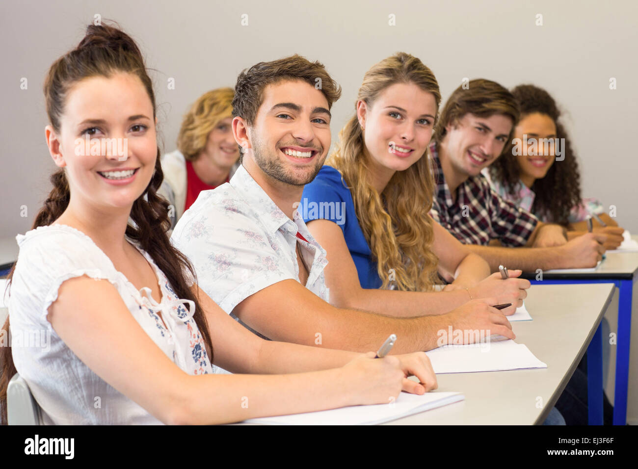 Students writing notes in classroom Stock Photo - Alamy