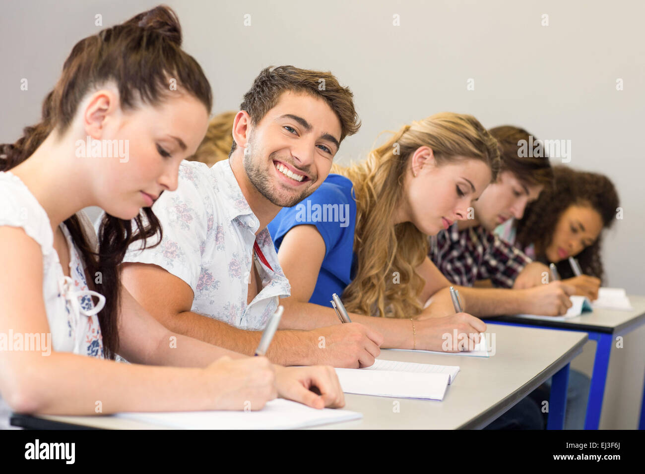Students writing notes in classroom Stock Photo - Alamy