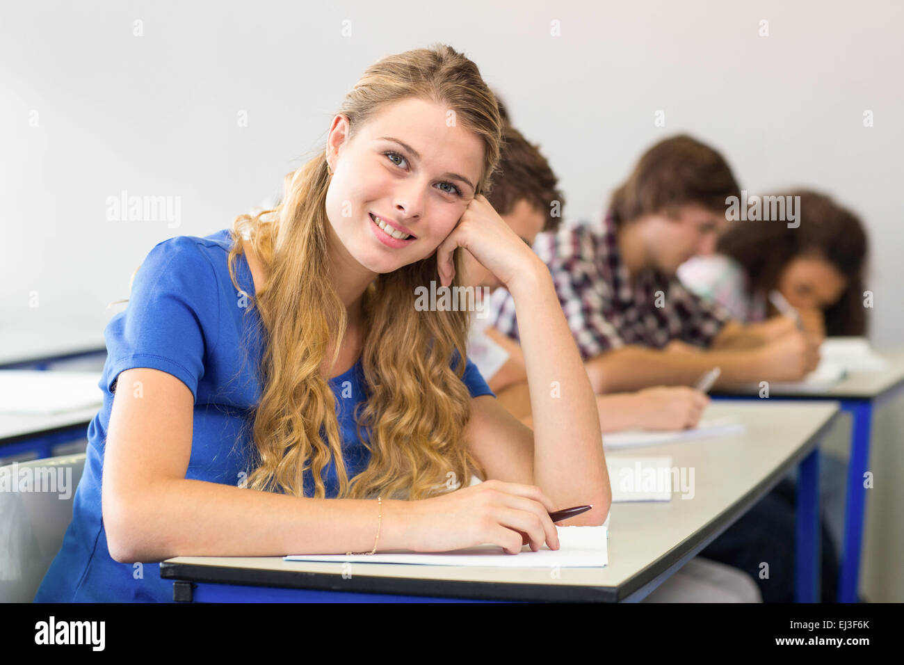 Students writing notes in classroom Stock Photo - Alamy