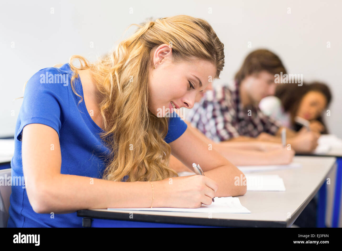 Students writing notes in classroom Stock Photo - Alamy
