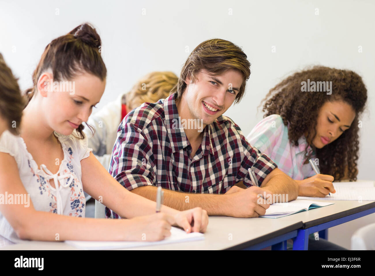 Students writing notes in classroom Stock Photo - Alamy
