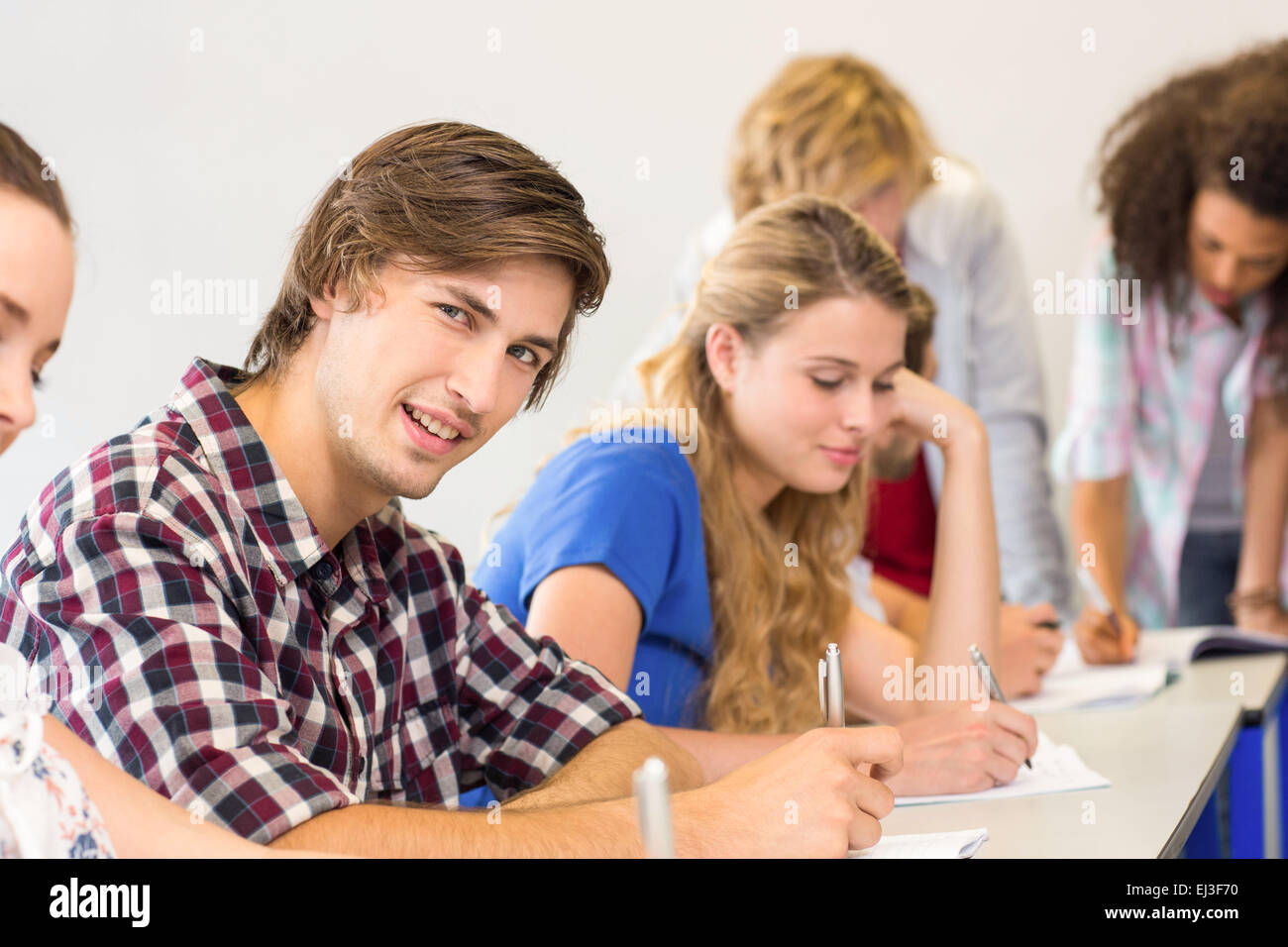 Students writing notes in classroom Stock Photo - Alamy