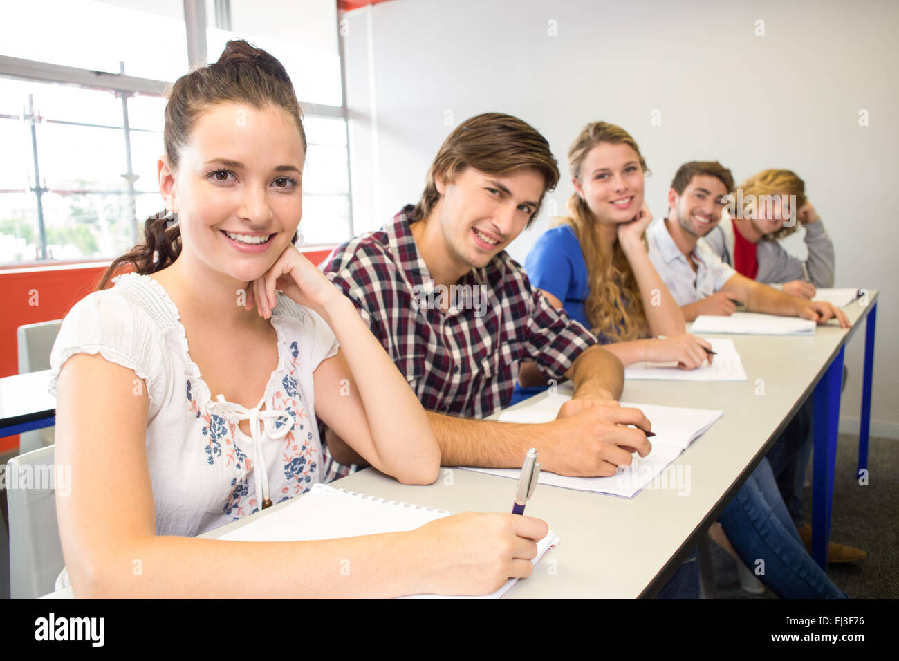 Students writing notes in classroom Stock Photo - Alamy