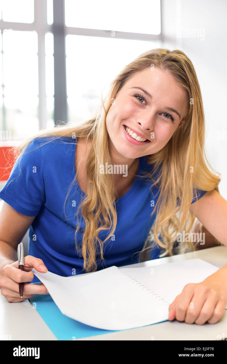 Female student writing notes in classroom Stock Photo - Alamy
