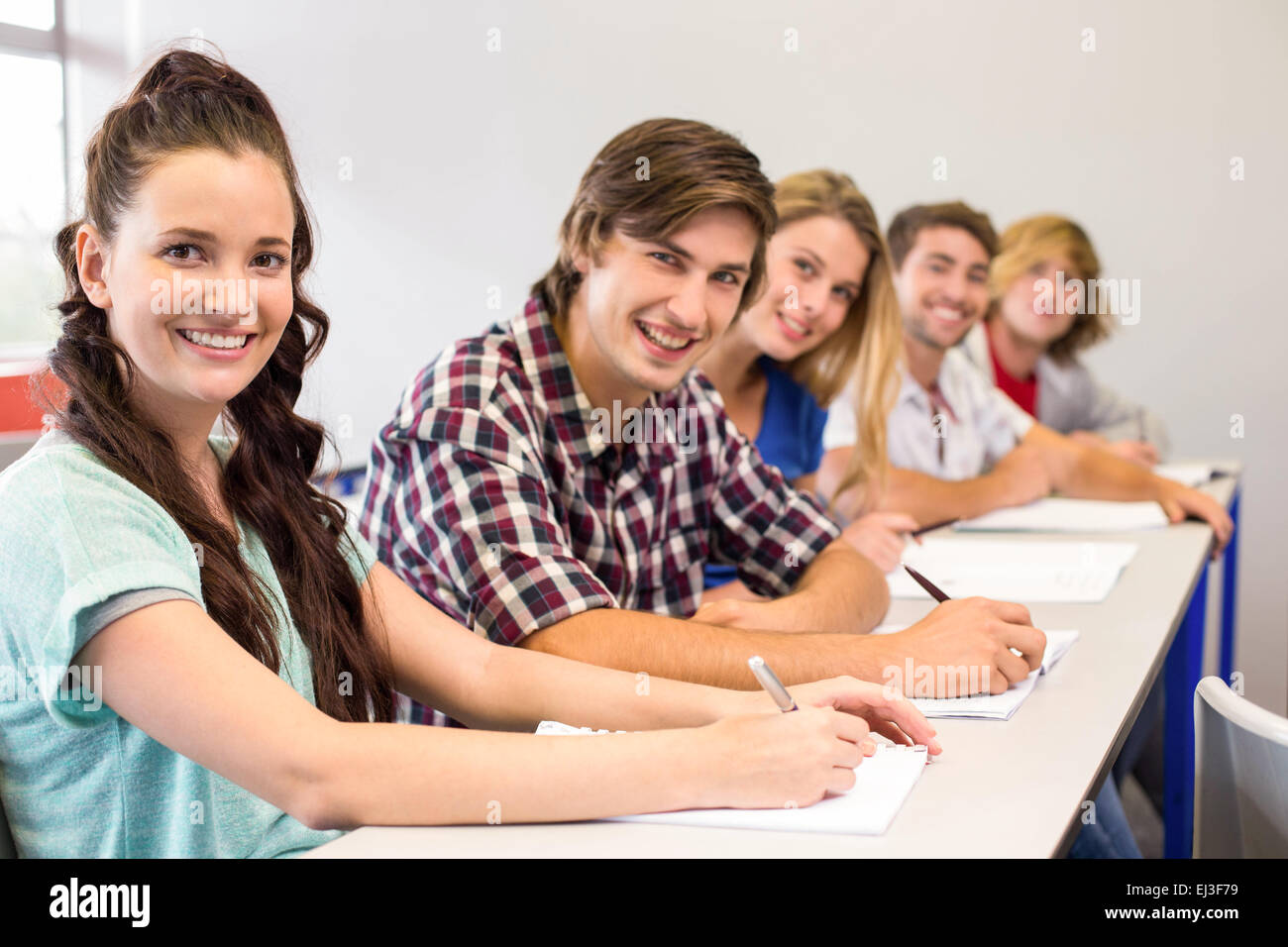 Students writing notes in classroom Stock Photo - Alamy