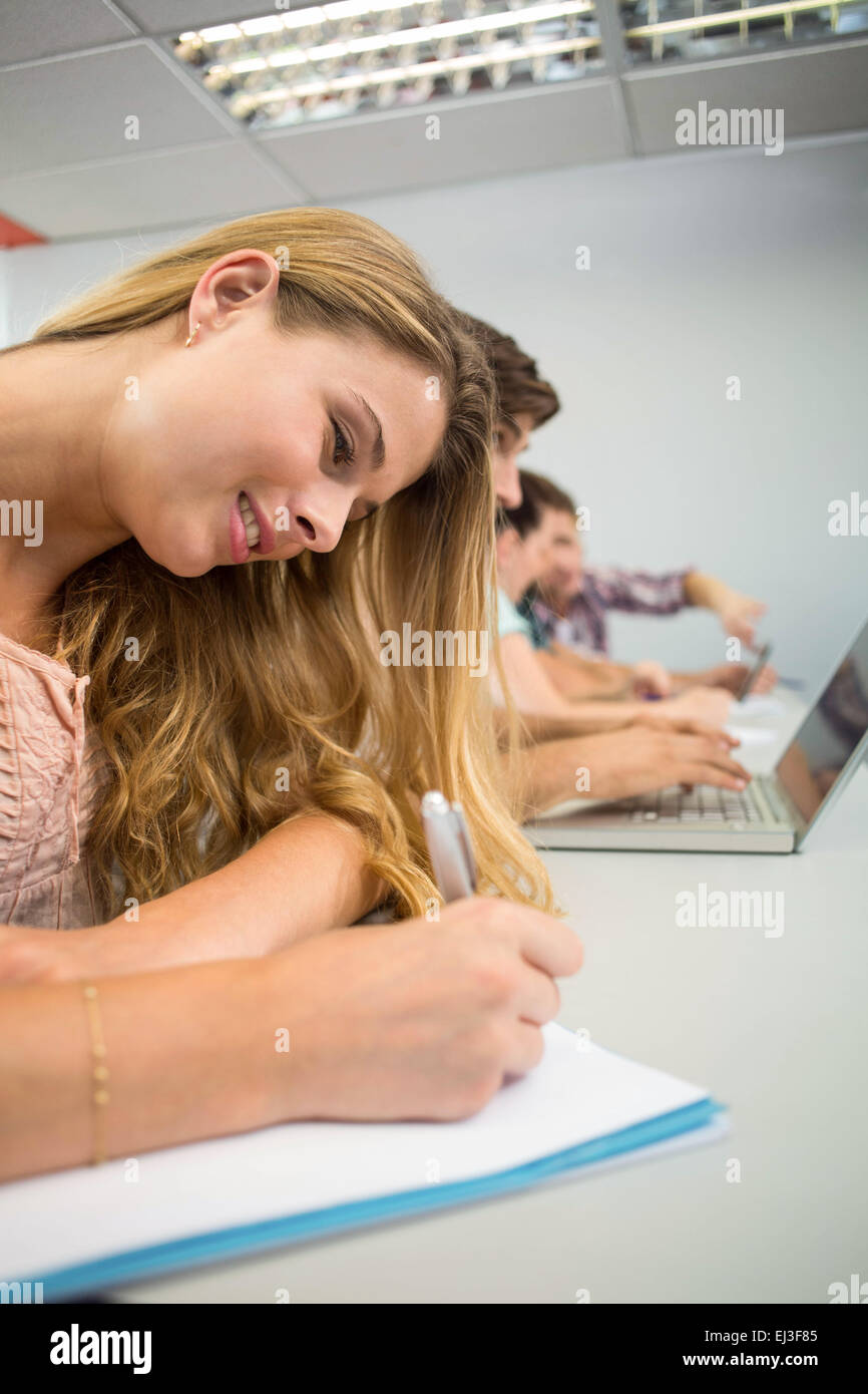 Students writing notes in classroom Stock Photo - Alamy