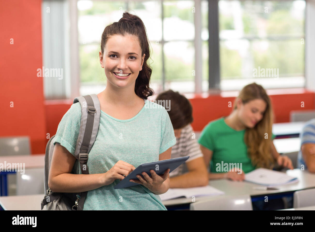Female student using digital tablet in classroom Stock Photo - Alamy